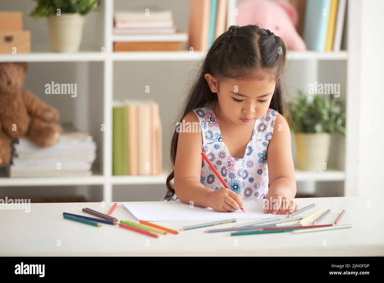 Creative little girl drawing with pencils at her table Stock Photo - Alamy
