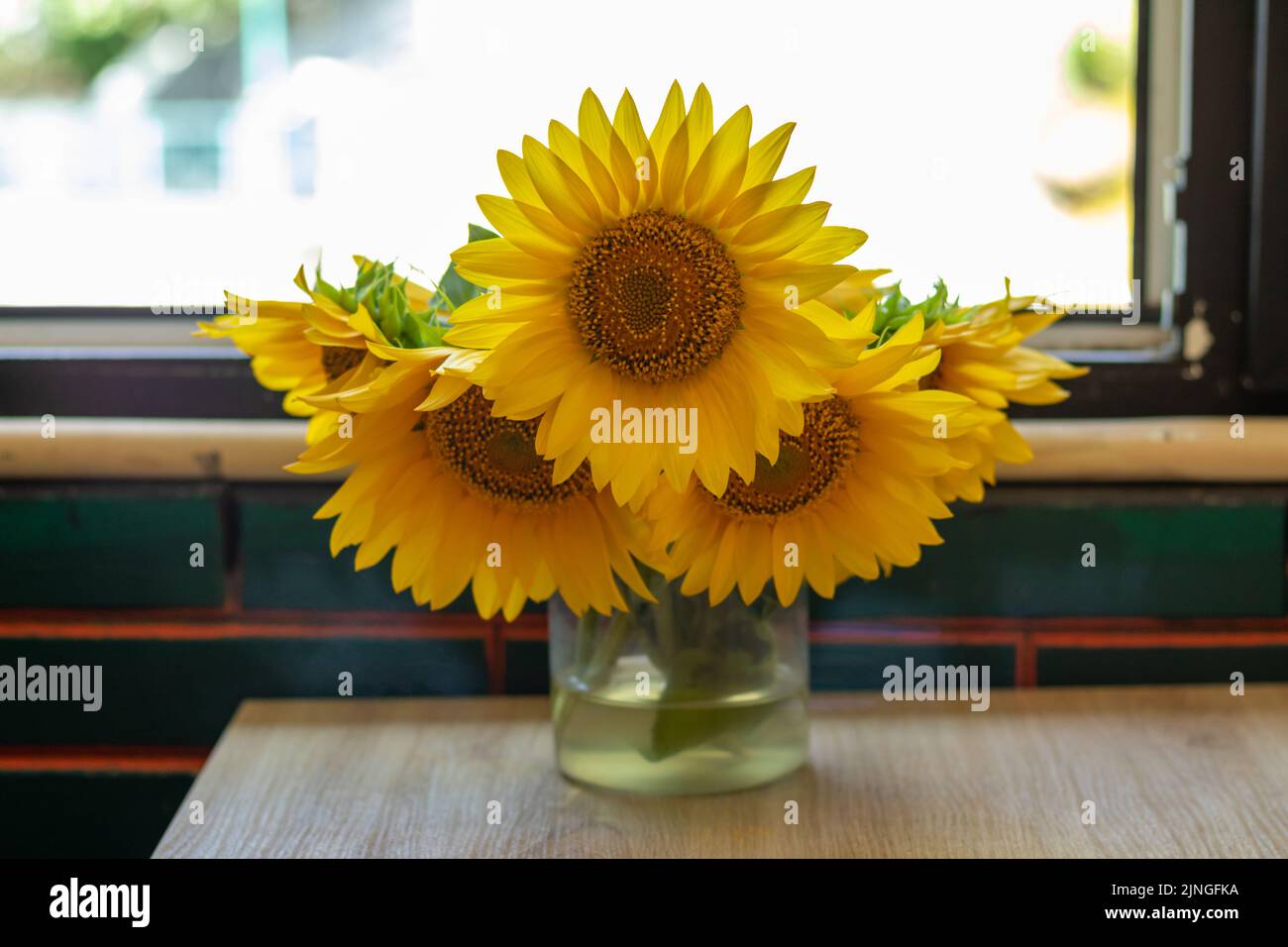A beautiful bouquet of sunflowers in a glass vase on the window Stock ...