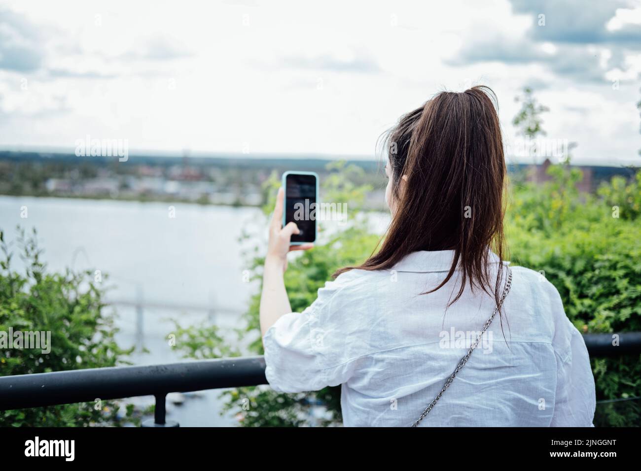 Young girl shooting photo or video on her mobile phone. Girl using her ...