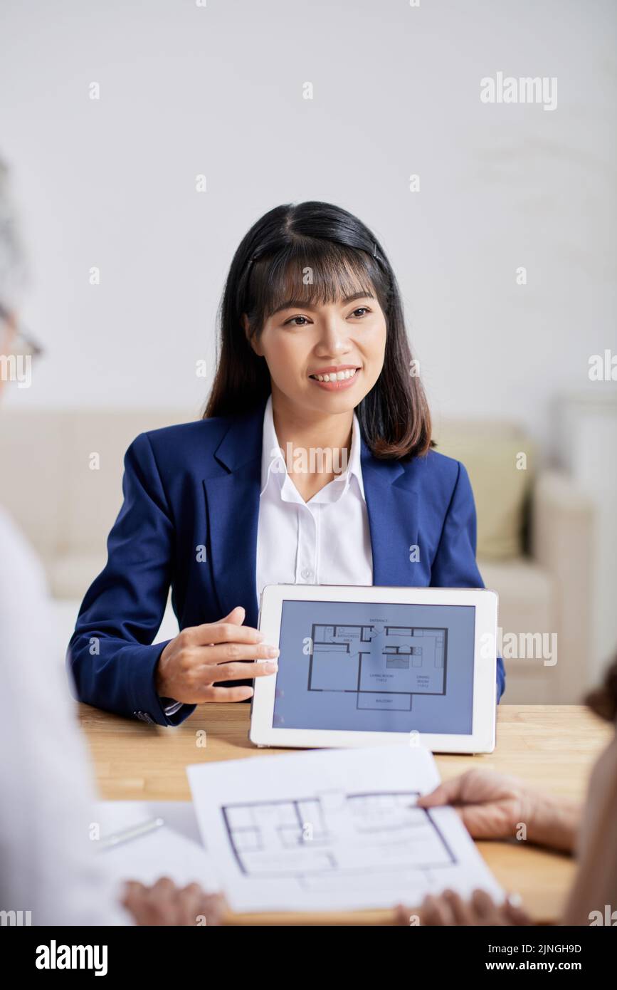 Waist-up portrait of attractive Asian interior designer wearing suit ...