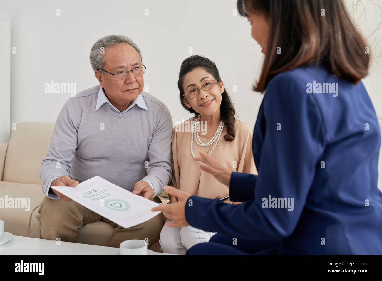 Back view of friendly agent in formalwear explaining details of life ...