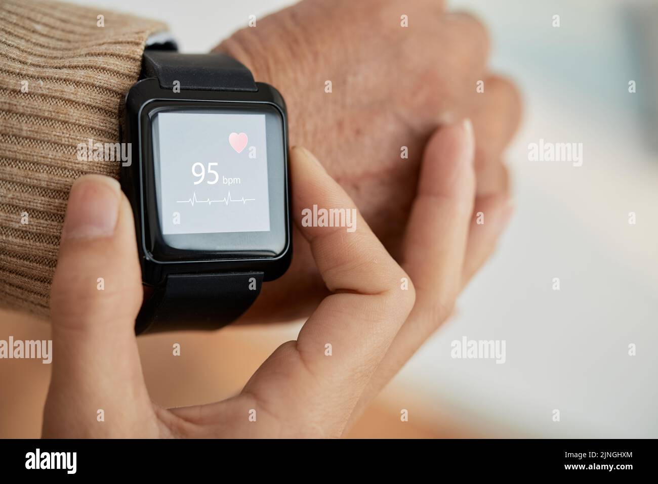 Close-up shot of unrecognizable doctor checking pulse of her senior ...