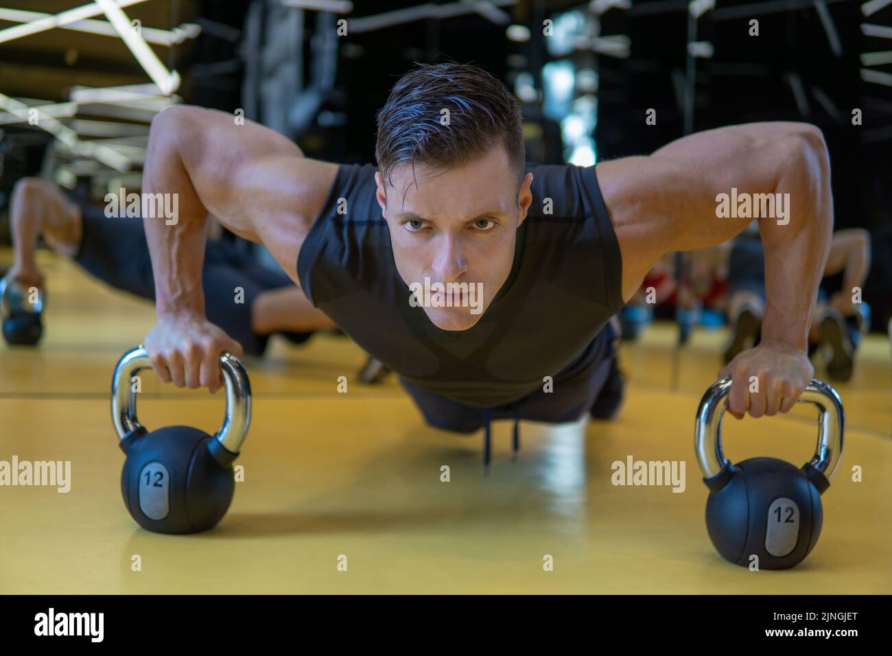 A Caucasian Fitness guy workout pushups with kettlebells Stock Photo ...