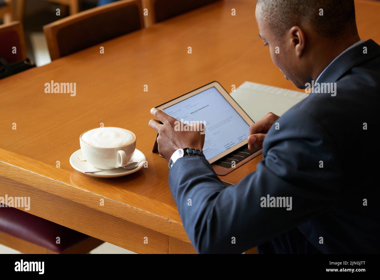 Businessman checking information in his tablet computer Stock Photo - Alamy