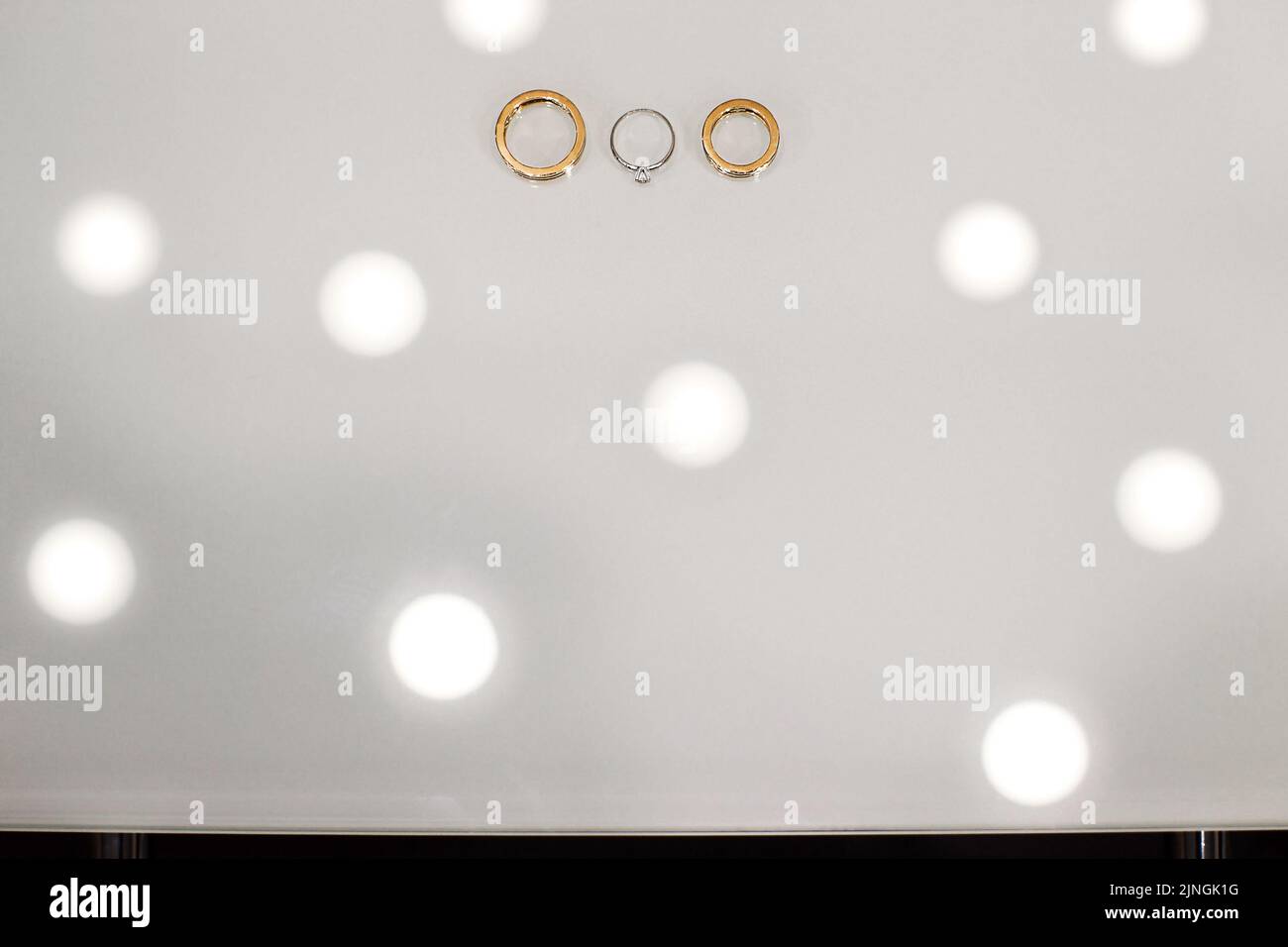 Three wedding rings on a beige background Stock Photo - Alamy