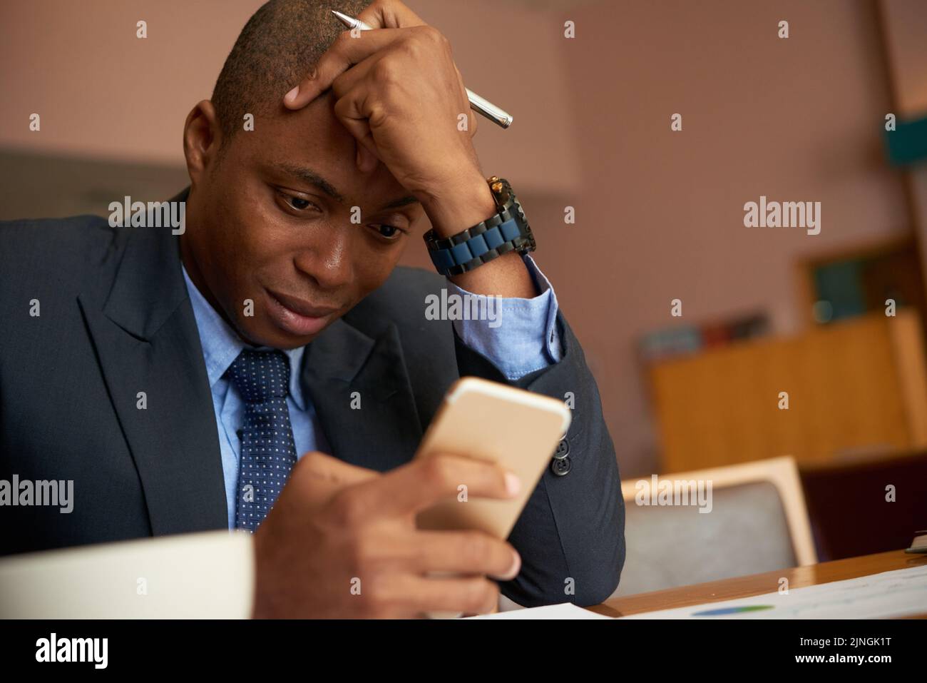 Frustrated African-American businessman reading message on his ...