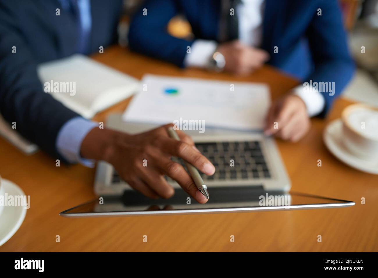 Hand of businessman pointing into laptop screen to explain something ...