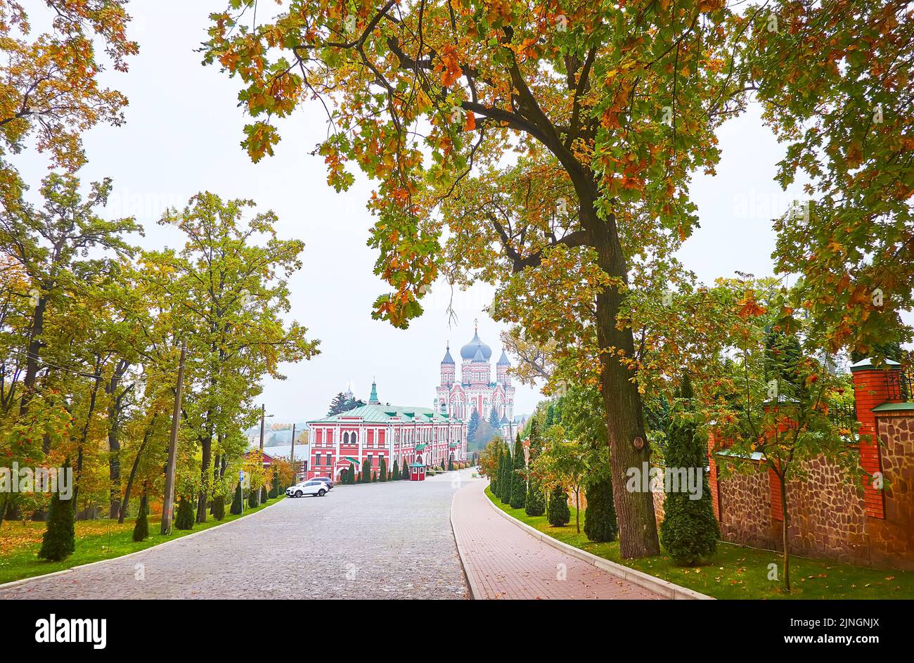 The alley of autumn park with a view on St Panteleimon Monastery in fog ...