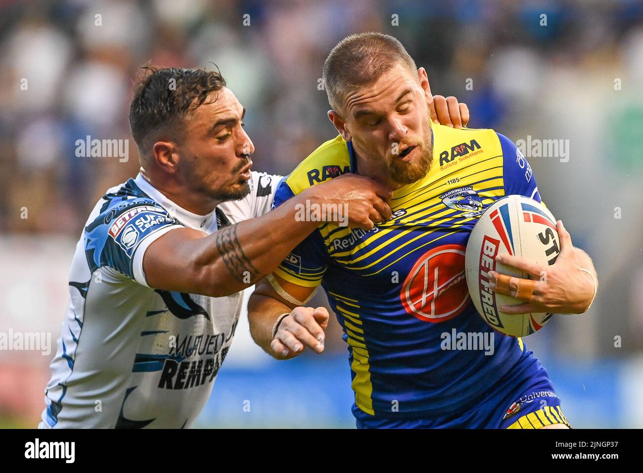 Matt Dufty #36 of Warrington Wolves is tackled by Tony Gigot #31 of ...