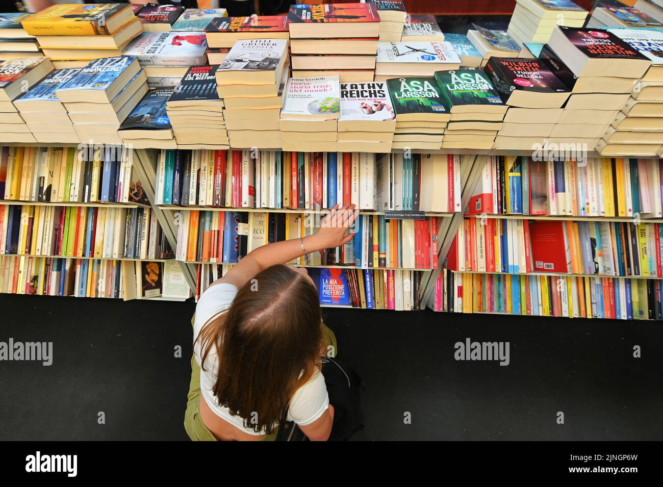 A top view closeup of a Teenager choosing books from the shelves at ...