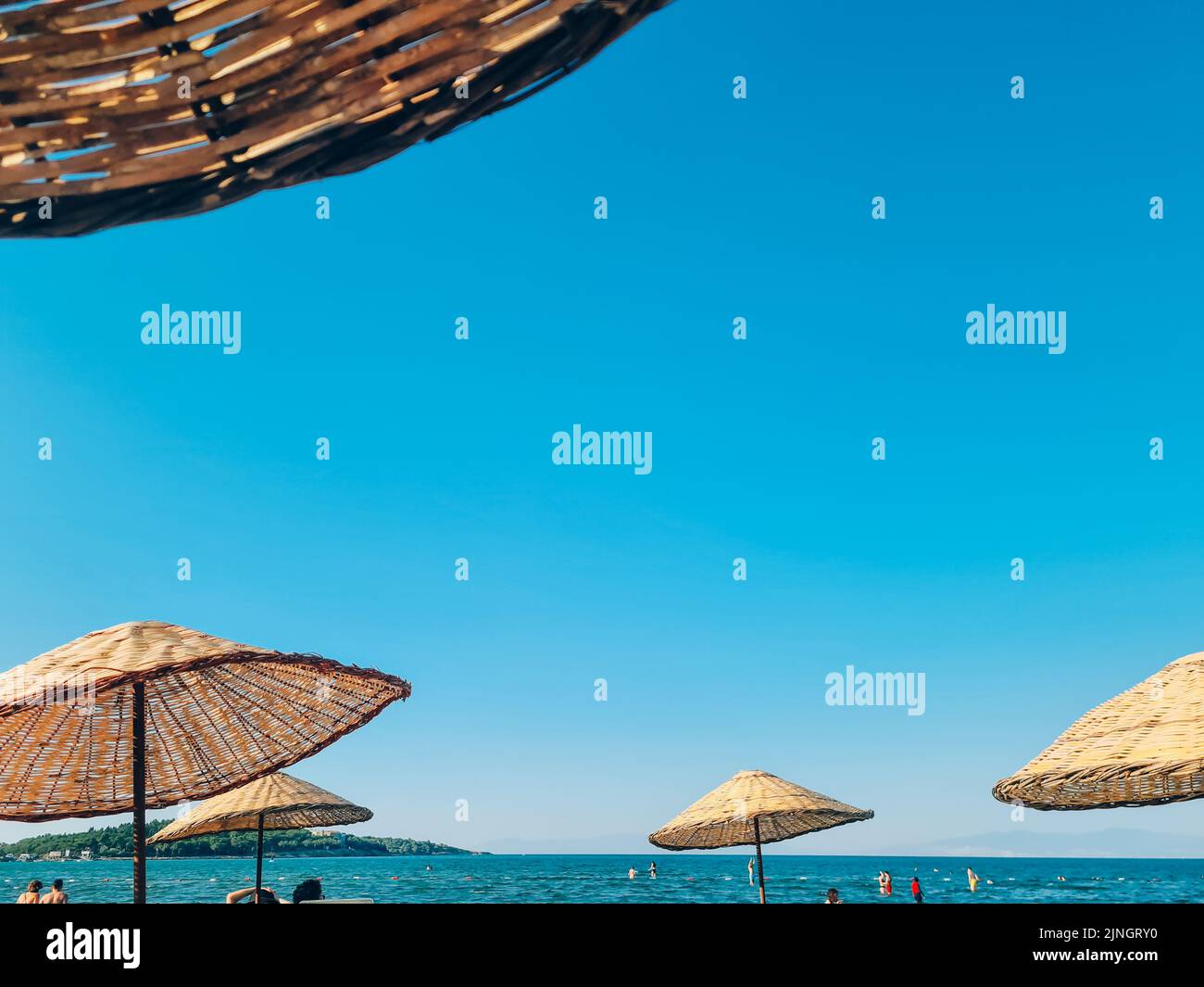 Bamboo beach umbrella on blue sky background Stock Photo - Alamy
