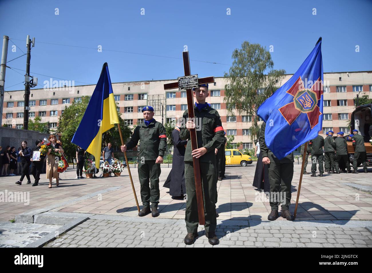 Soldiers of the National Guard of Ukraine carry flags and a cross ...