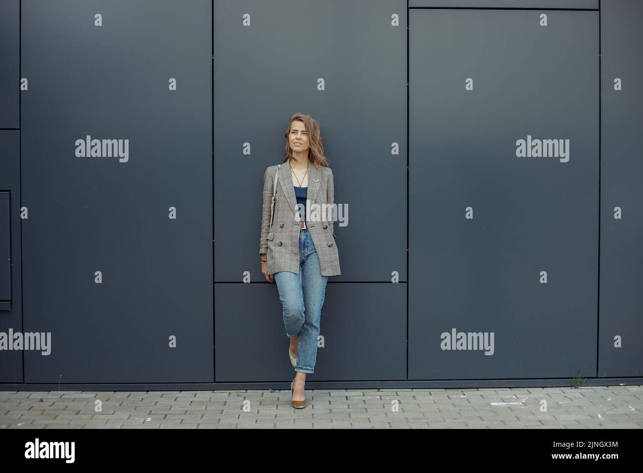 Full length photo of thinking young businesswoman standing on one leg ...