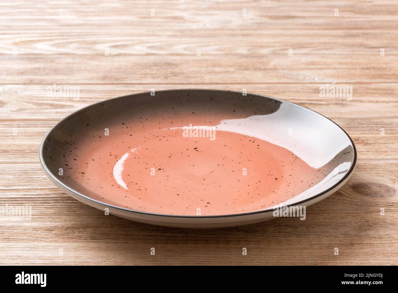 Perspective view of empty red plate on wooden background. Empty space ...