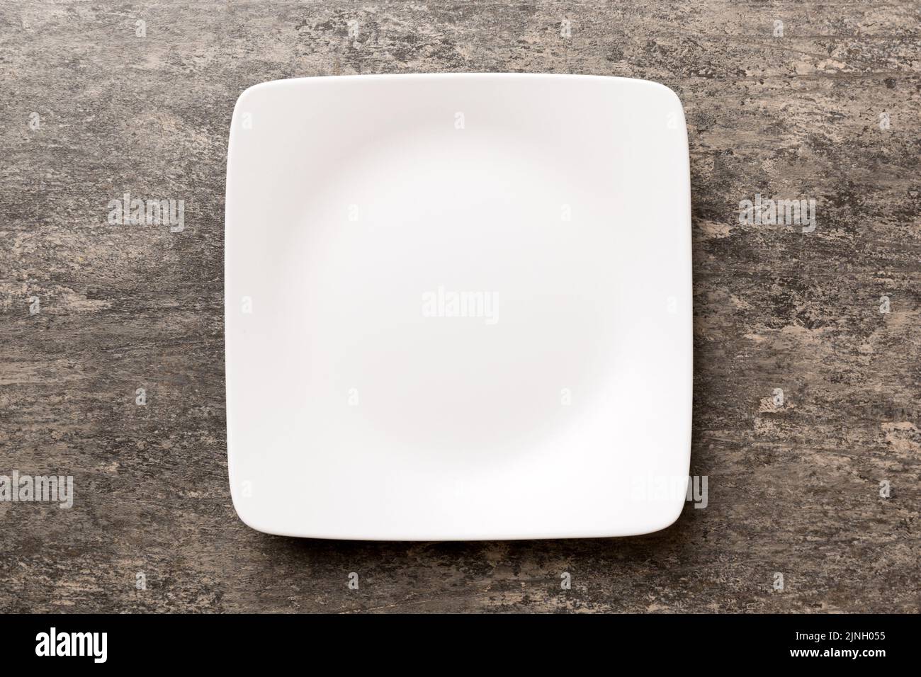 Top view of empty square plate on cement background. Empty space for ...
