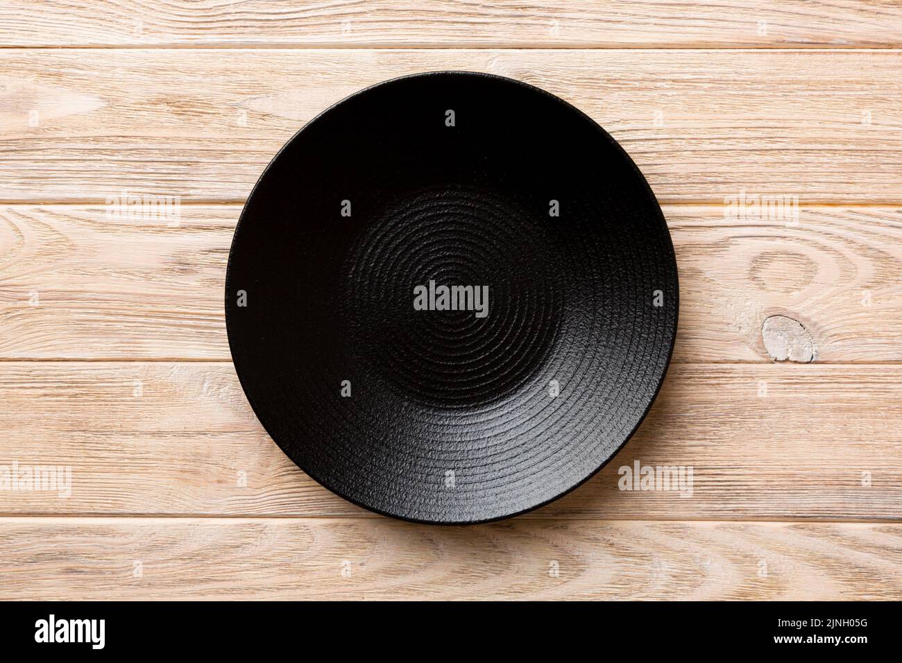 Top view of black plate on wooden background. Empty space for your ...