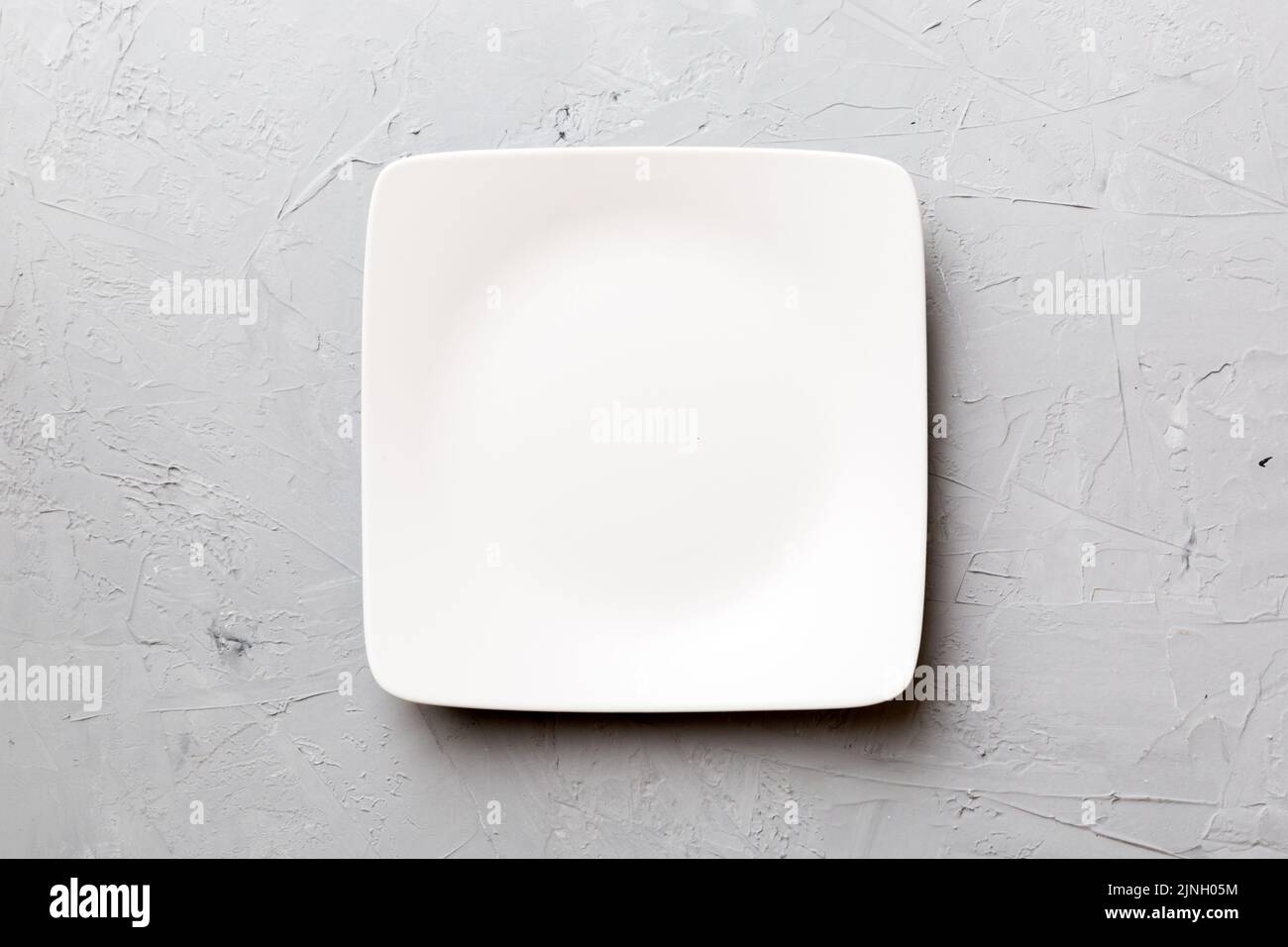 Top view of empty square plate on cement background. Empty space for ...