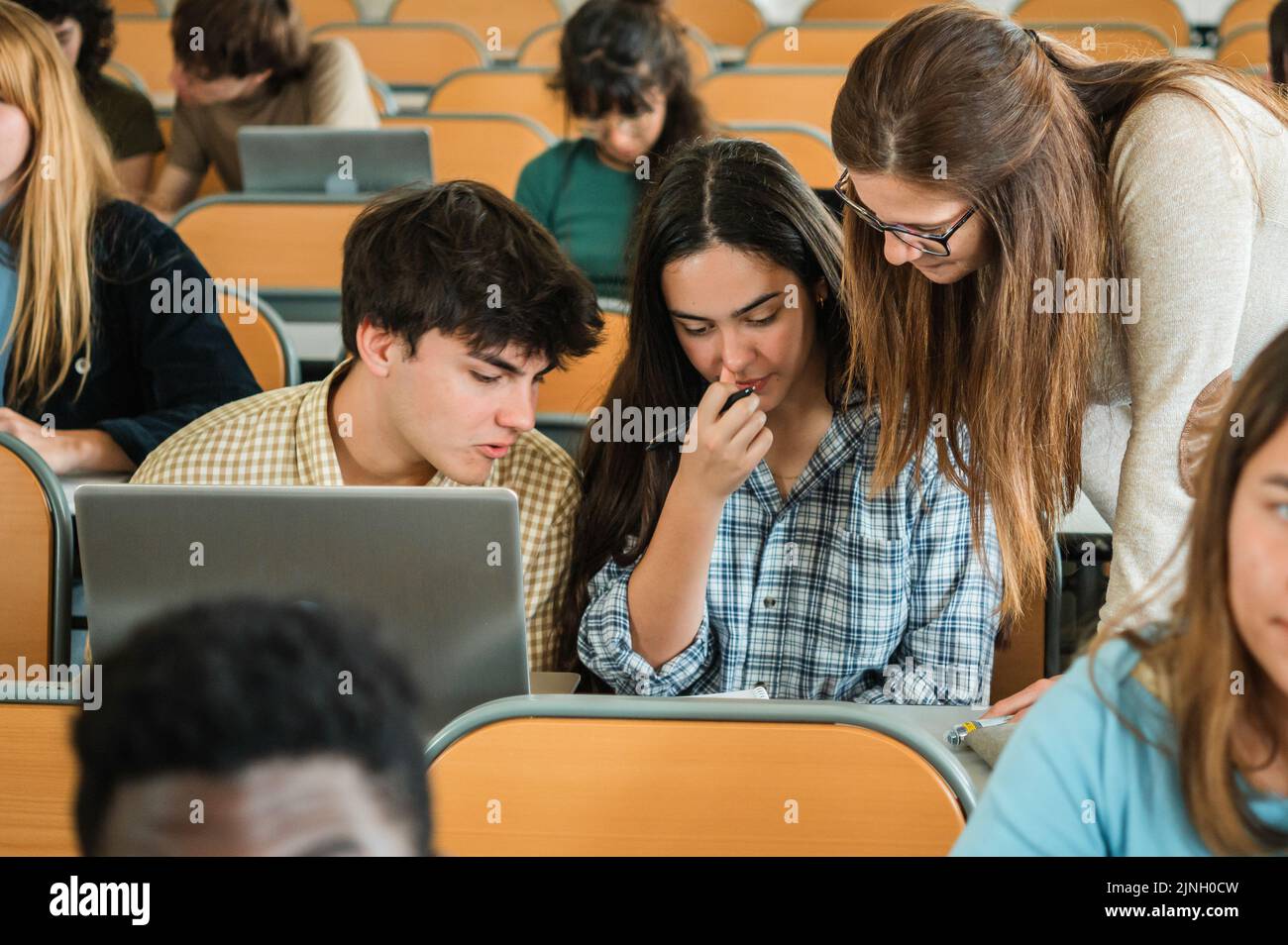 Teacher helping students with assignment Stock Photo - Alamy