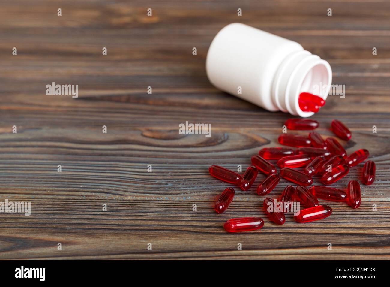 Red pills spilled around a pill bottle. Medicines and prescription ...