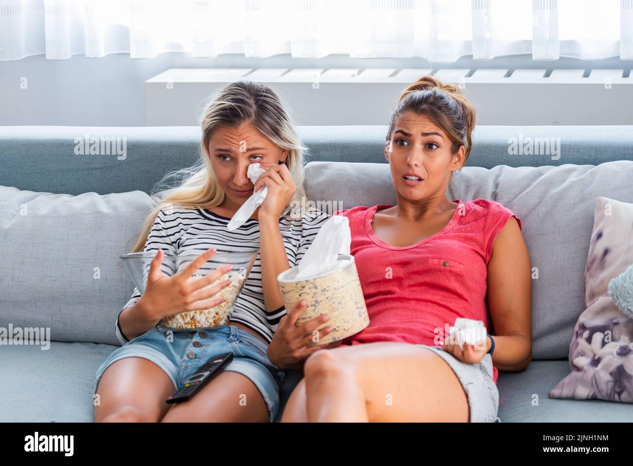 Two sentimental women friends upset crying and wiping tears with ...