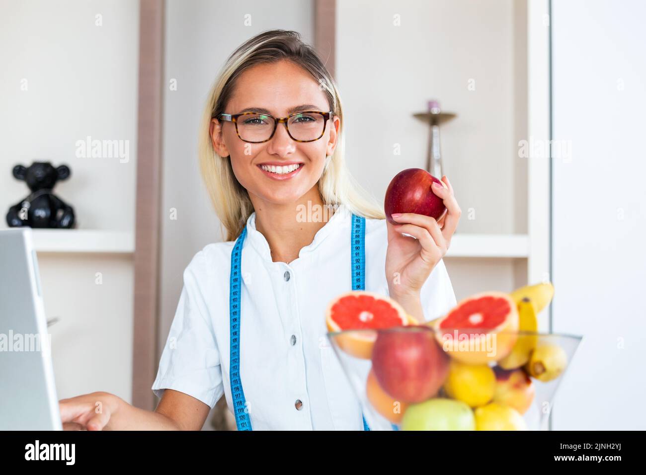 Portrait of young smiling female nutritionist in the consultation room ...