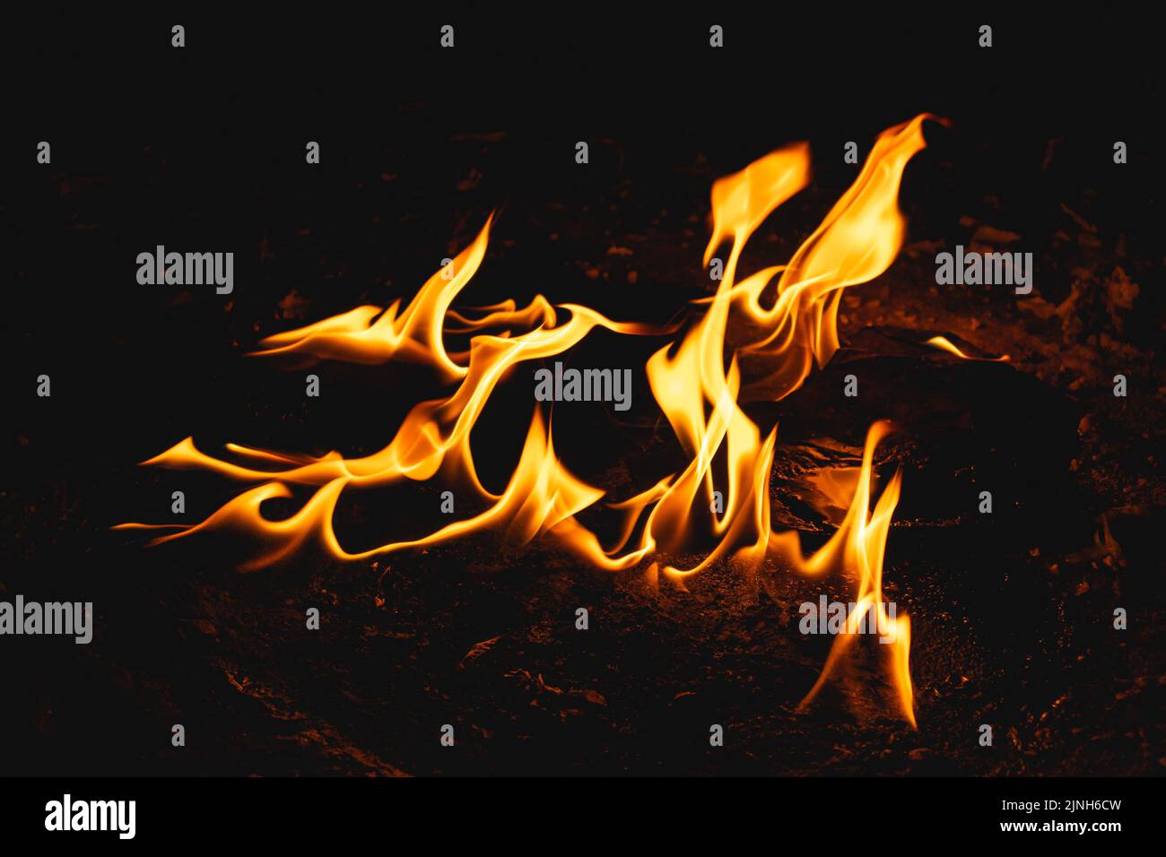 Flames of fire burning on the ground Stock Photo - Alamy