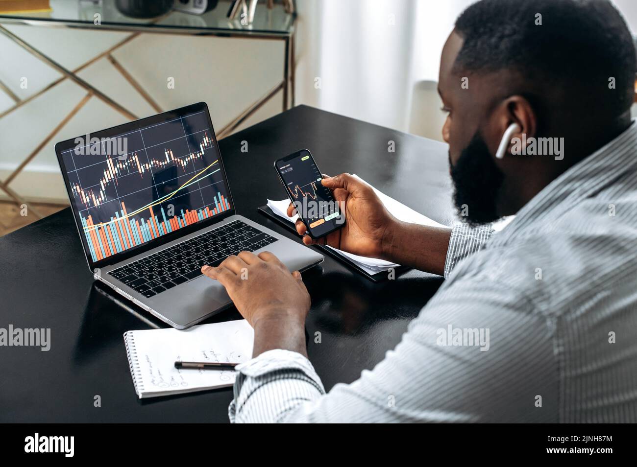 Financial trading charts on laptop and smartphone screens. A successful ...