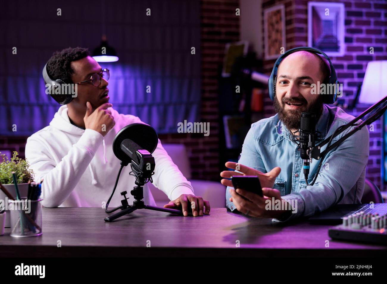 Team of vloggers filming podcast video show in modern studio, reading ...