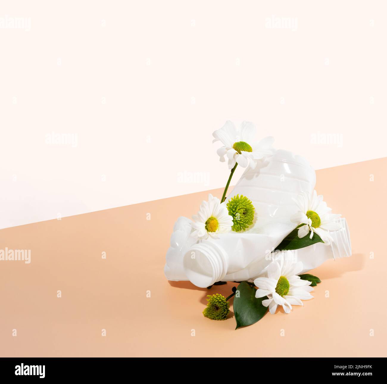 Negative impact on nature. Plastic bottles crush beautiful flowers on a ...