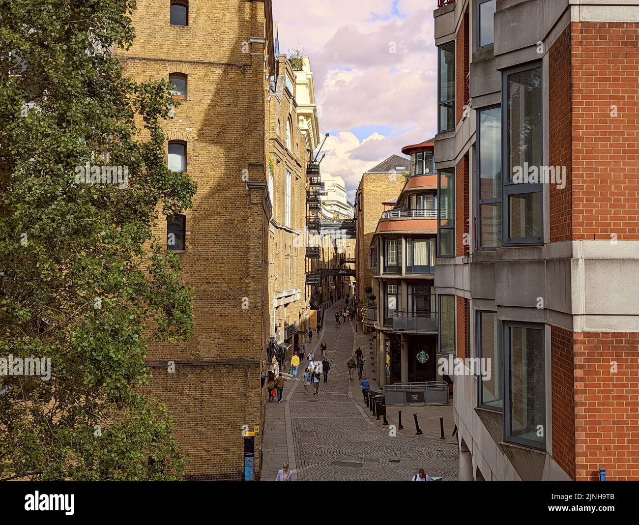 A historic riverside street of Shad Thames populated with people in ...