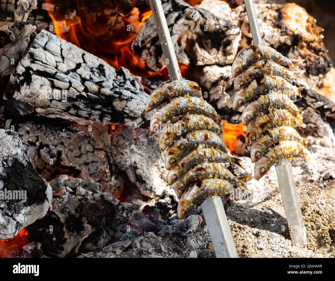 Andalusian sardines on spit being grilled on charcoals Stock Photo - Alamy