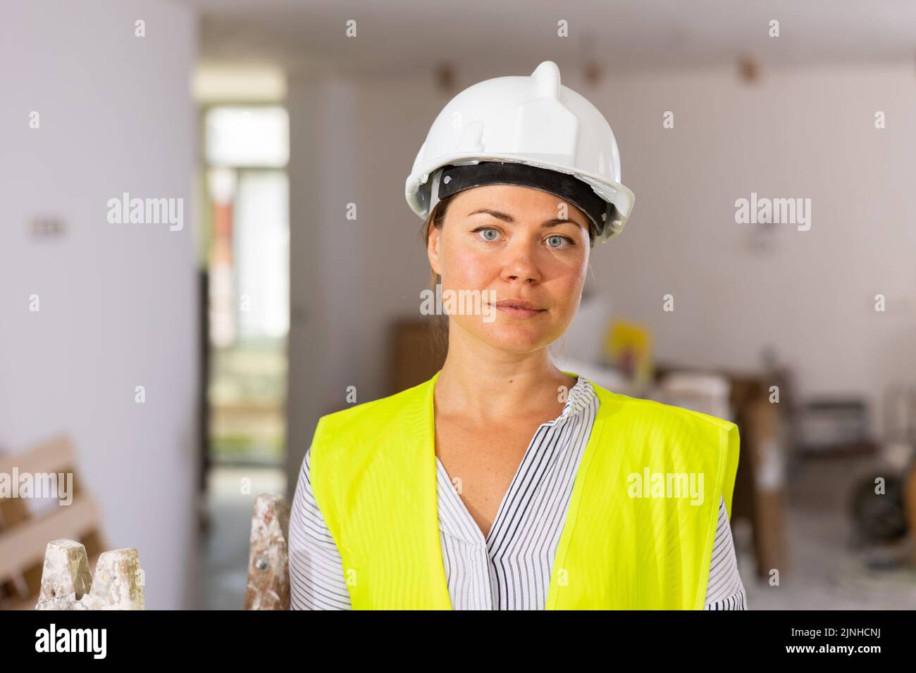 Confident female civil engineer standing inside building under ...