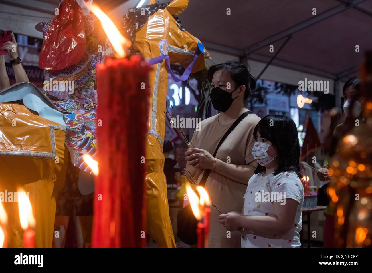 Ethnic Chinese pray in front of a paper-made horse during the Hungry ...