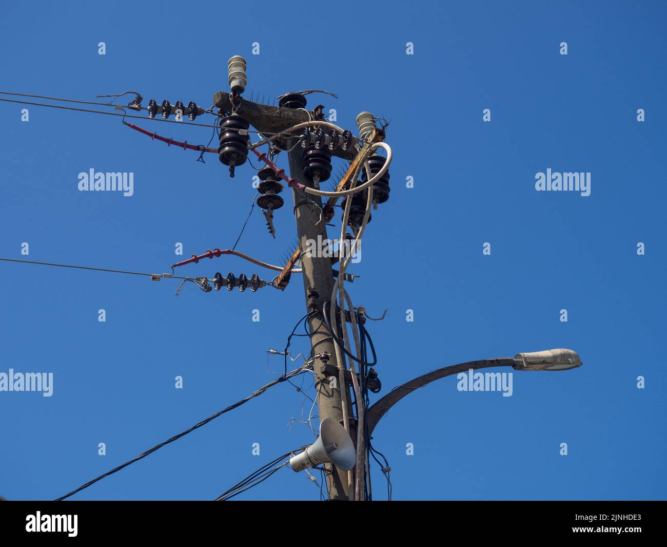Electrification. A pole entangled with many wires. Power pole. Old ...