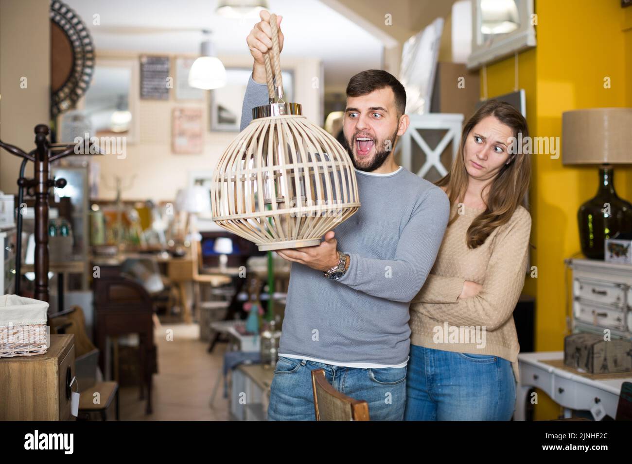 Raptured guy and surprised girl wth hanging lamp Stock Photo - Alamy