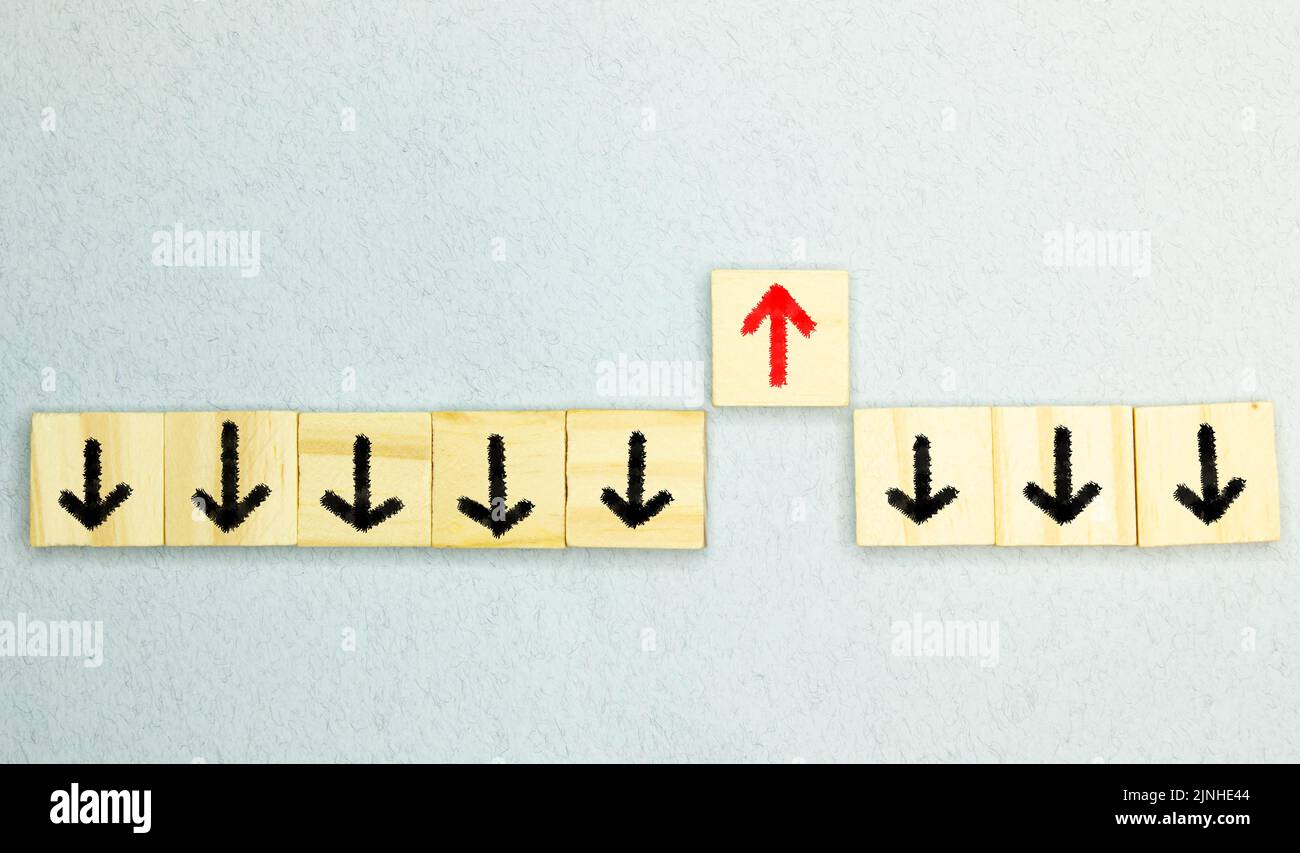 Wooden block with red arrow facing the opposite direction black arrows, Unique, think different ...