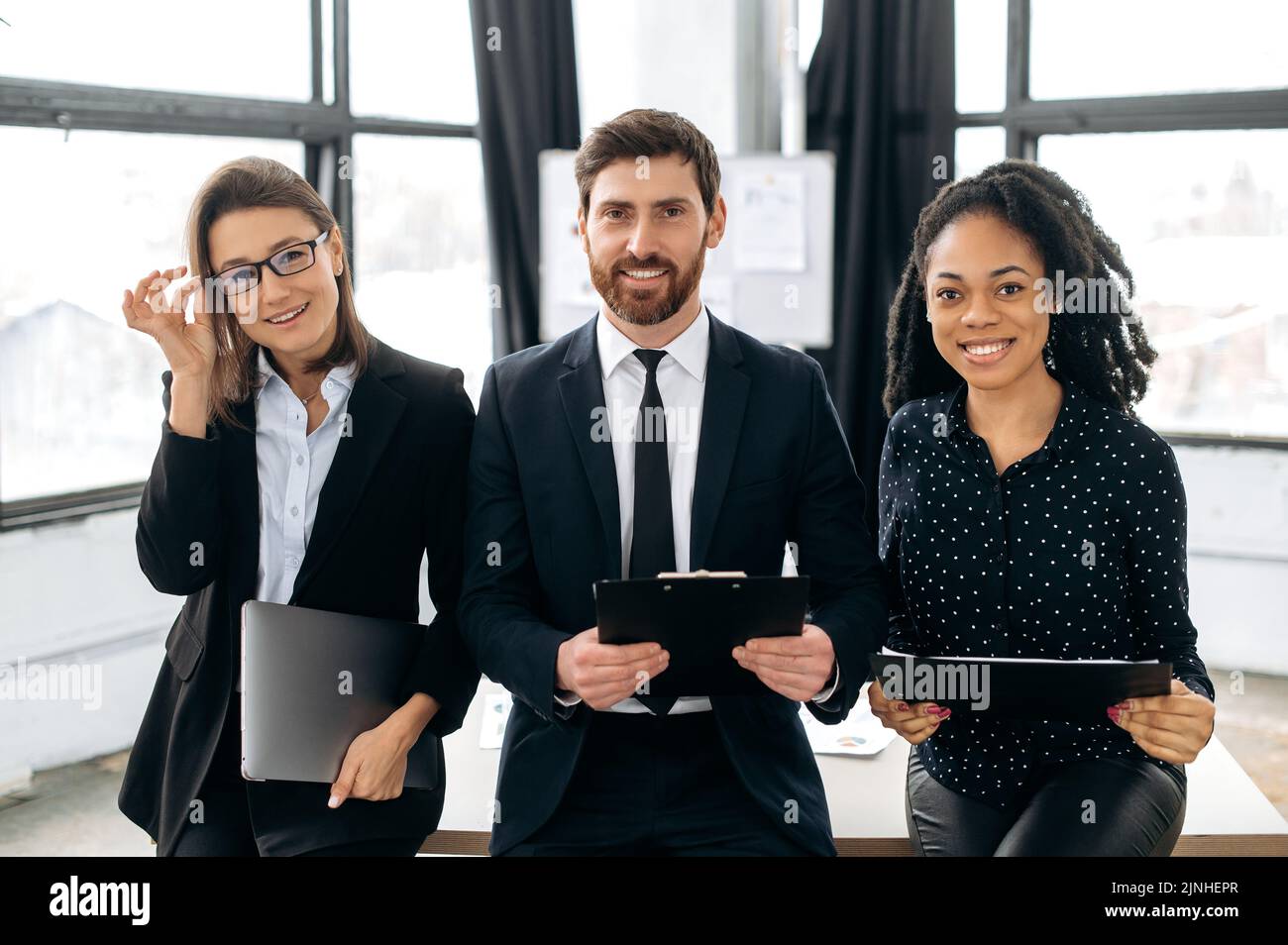 Elegant creative colleagues stand in modern office, show confidence and ...