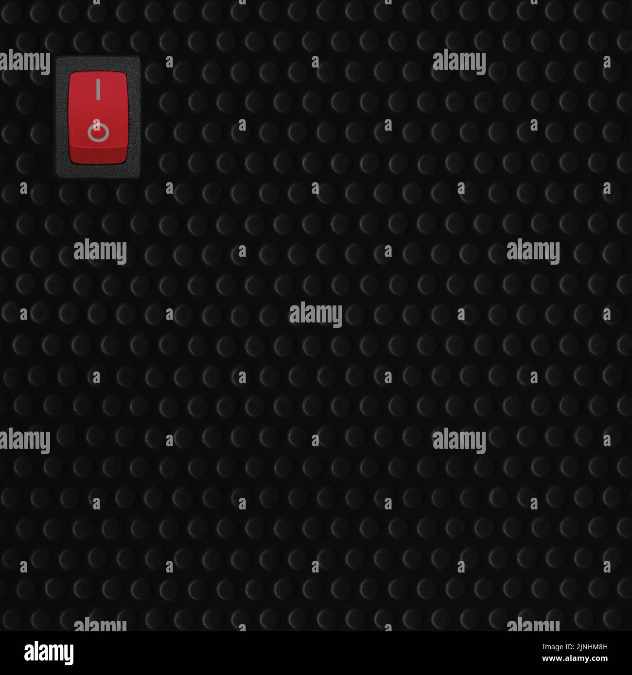 Red rectangle rocker power switch in on position, black abstract dot ...