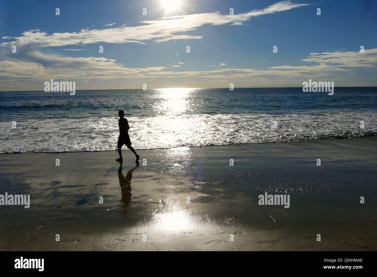 silhouette of man jogging on the beach near sunset Stock Photo - Alamy