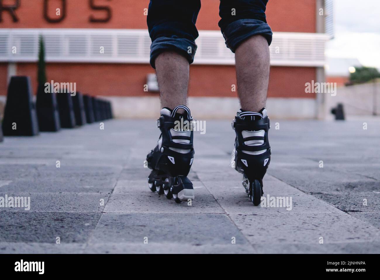 Pair of roller skates on the street rolling. Boy walking with his black ...