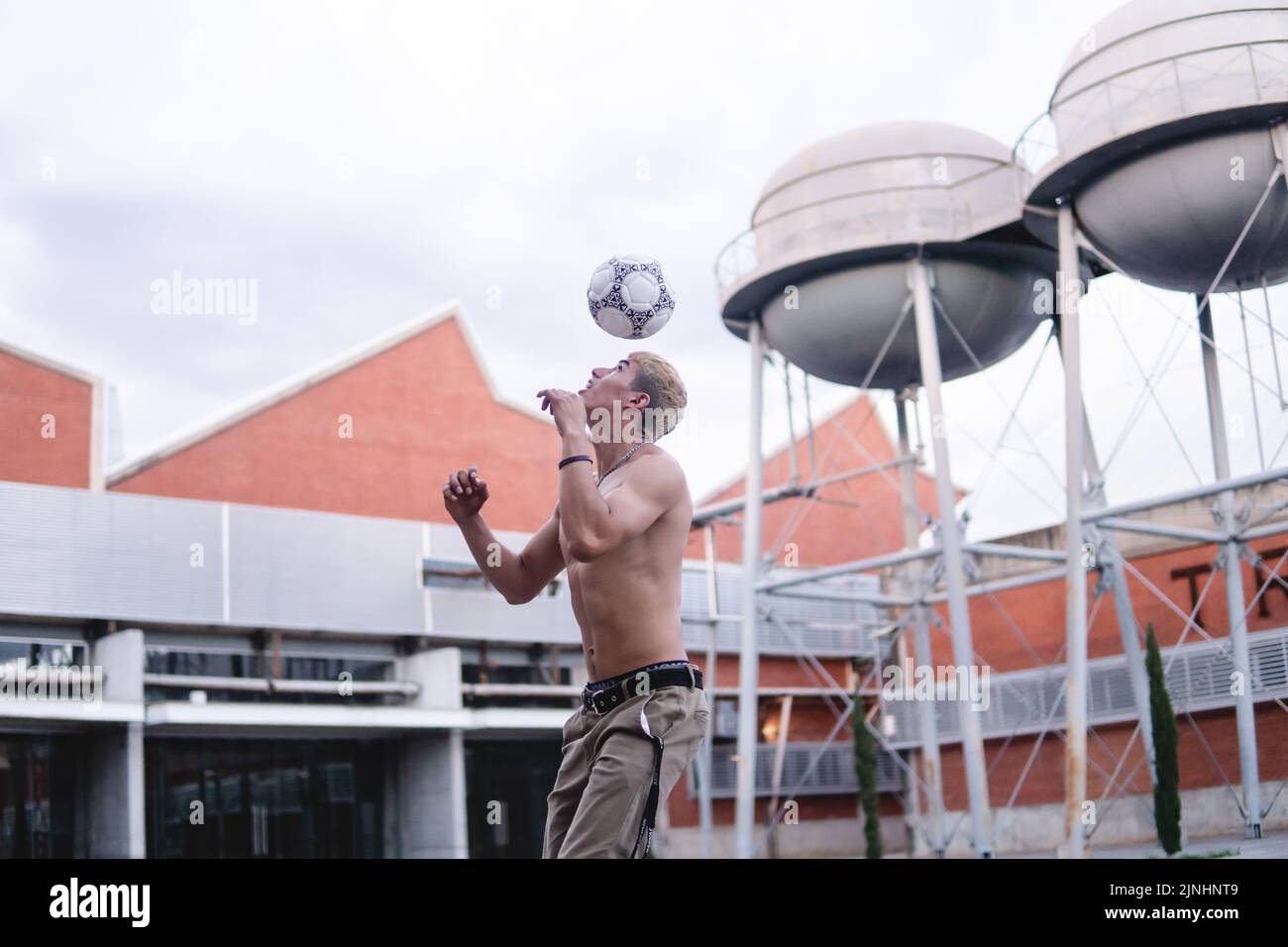 Hispanic Latino man dominating a soccer ball with his head. Athlete boy ...