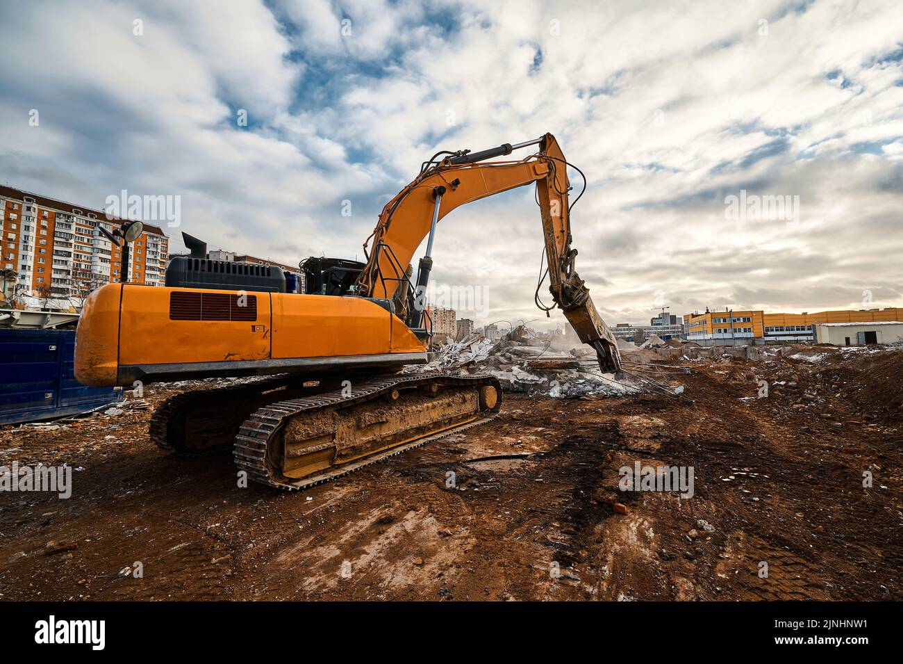 Excavator with hydraulic press breaks concrete leftovers Stock Photo - Alamy