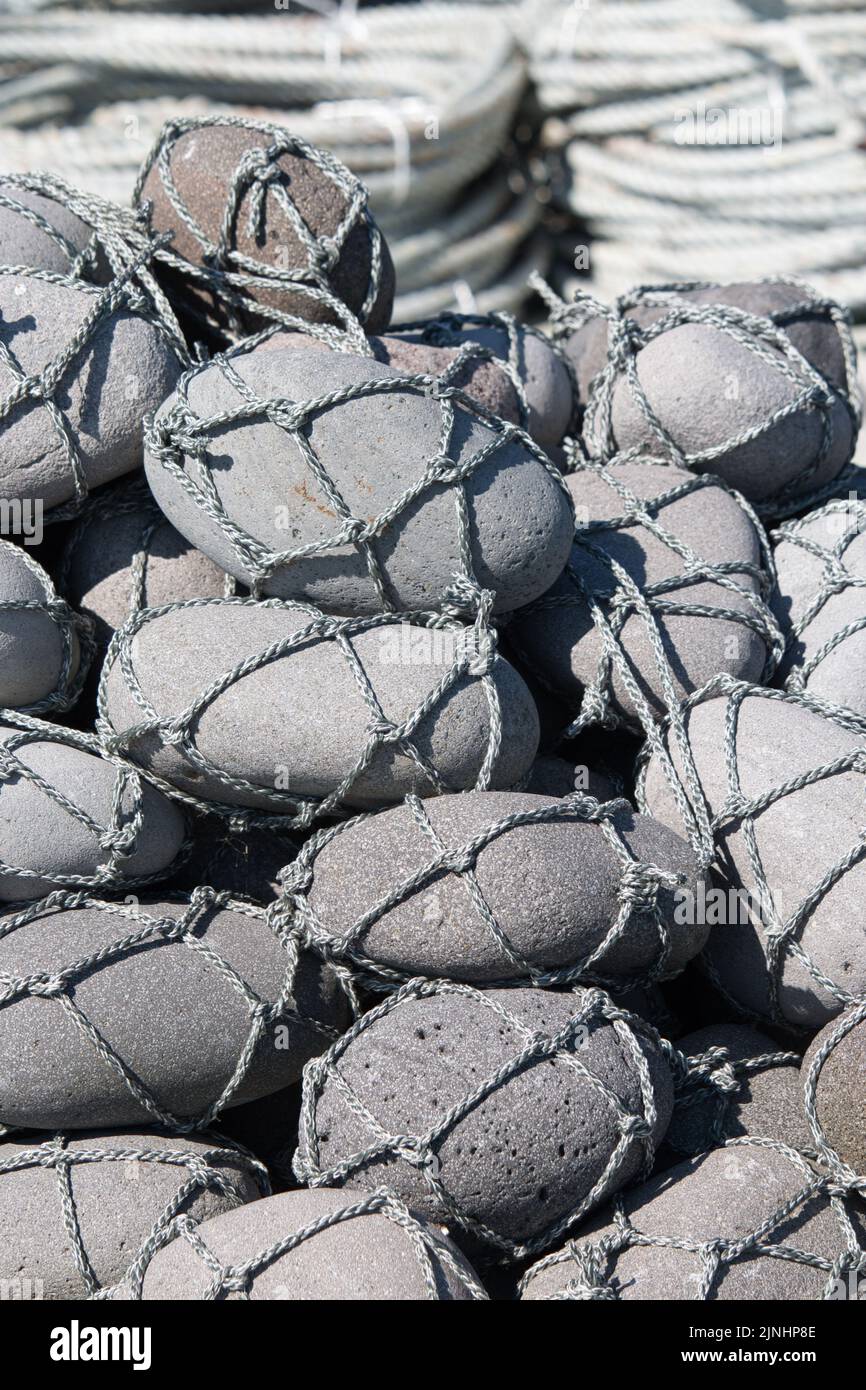 Grey rock weights tied with string Stock Photo - Alamy