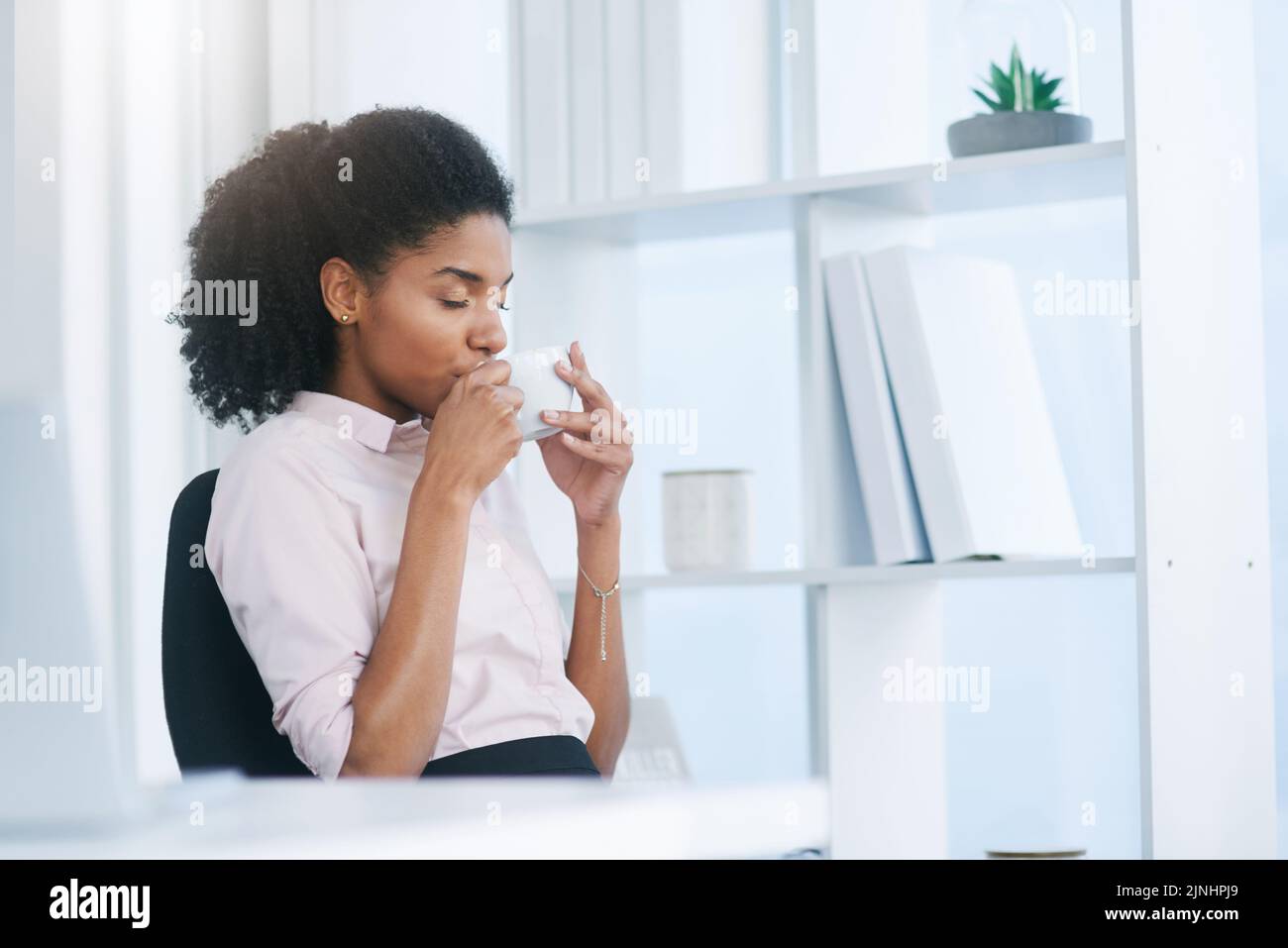 My systems just needs a few sips. a young businesswoman drinking a cup ...