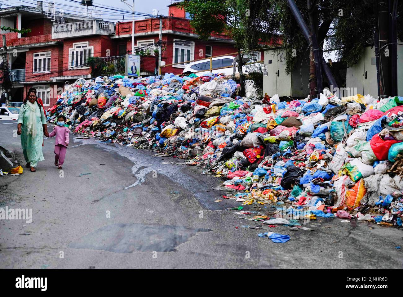 Kathmandu, Nepal. 11th Aug, 2022. A woman and child walk past ...