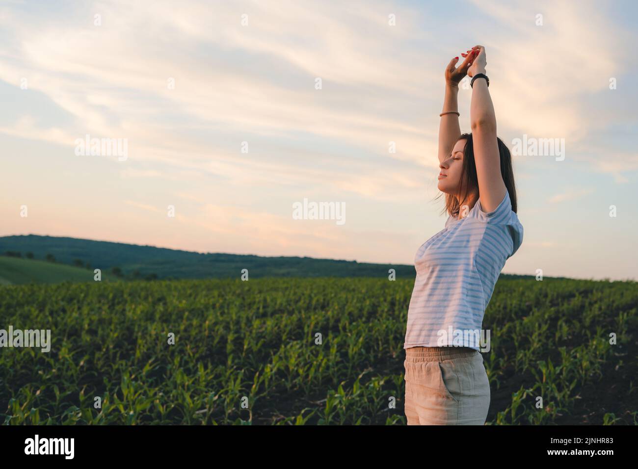 Young woman doing gymnastics in nature, in the morning in the green ...