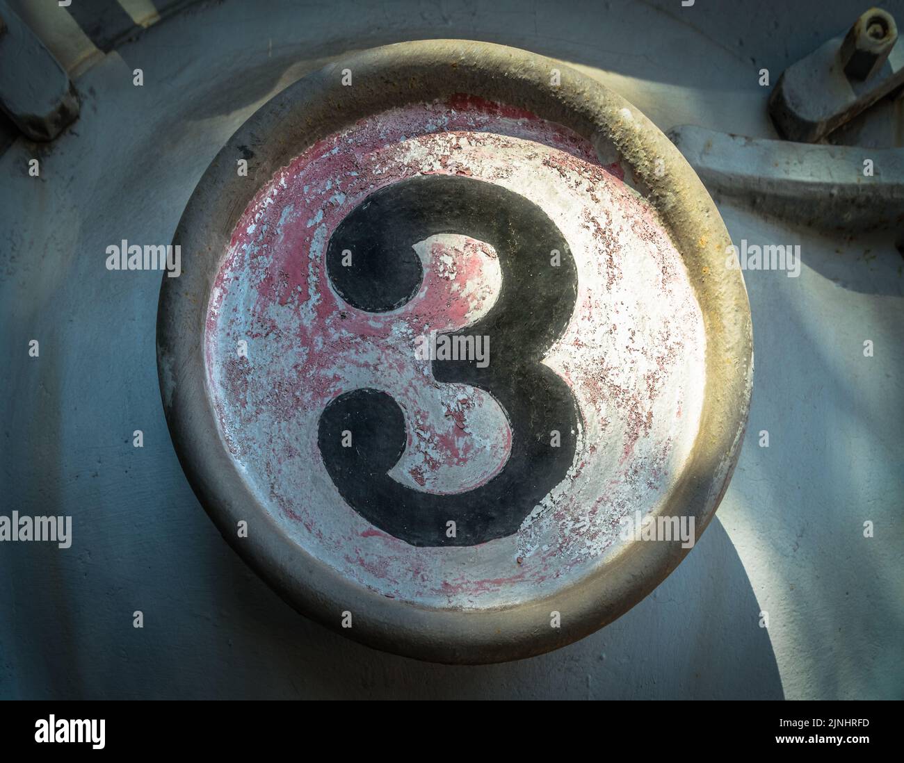 The black numeral '3' on the nose plate of a vintage steam engine ...