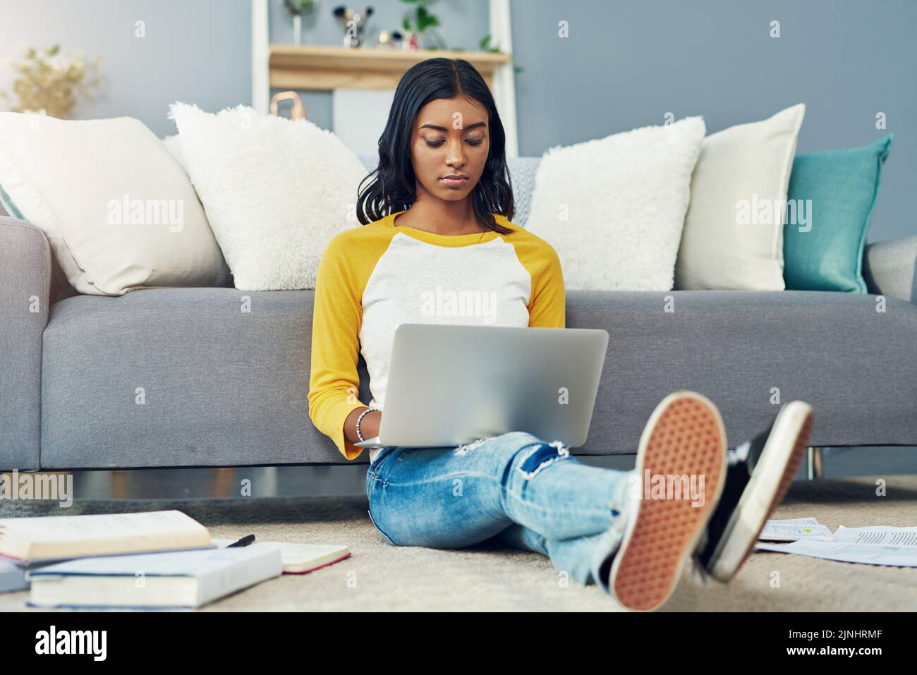 Focused on acing her finals. a young female student studying at home ...