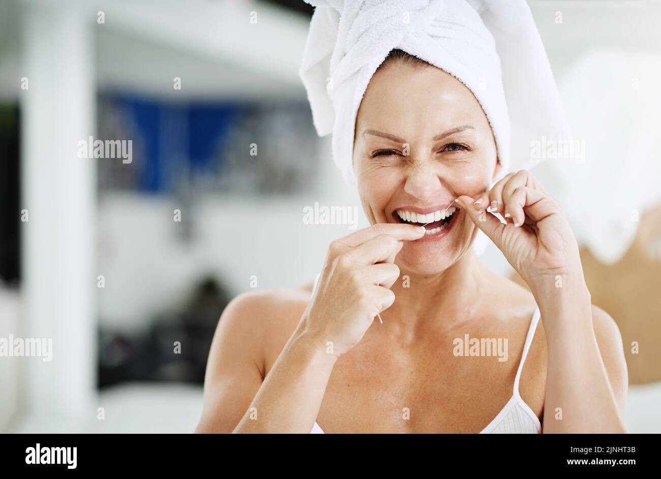Flossing Makes For Healthy Teeth A Mature Woman Flossing Her Teeth