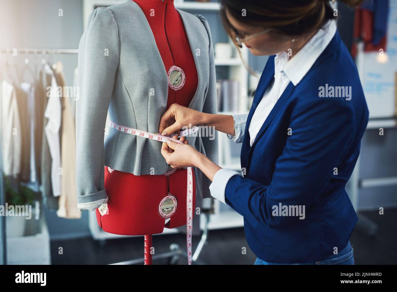 Getting the waist measurement. an attractive young fashion designer ...